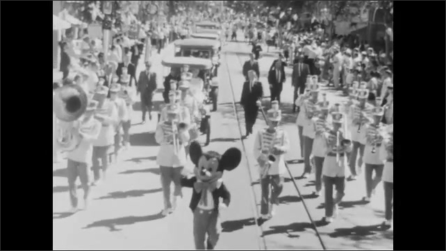 1950s: Train rolls through Disneyland. People spin in Teacup ride in ...