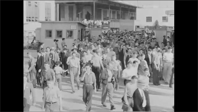 1940s: crowd of people walking through gate – Archival Footage