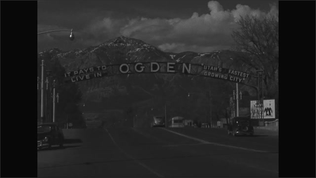 1940s: Vehicles pass under sign for Ogden, Utah. – Archival Footage