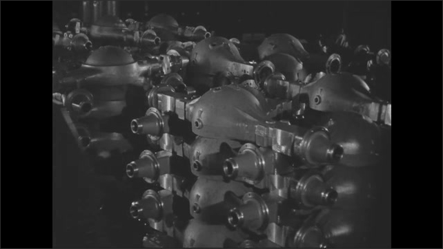 1930s: Stacks of assembled rear axles with differential covers. Worker ...