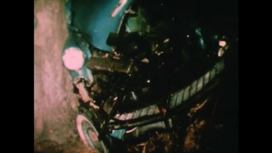 United States: 1950s: wreck of car at night after crash. Body of man ...