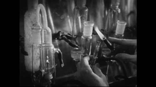 UNITED STATES 1950s : Scientist working in laboratory with glass test ...