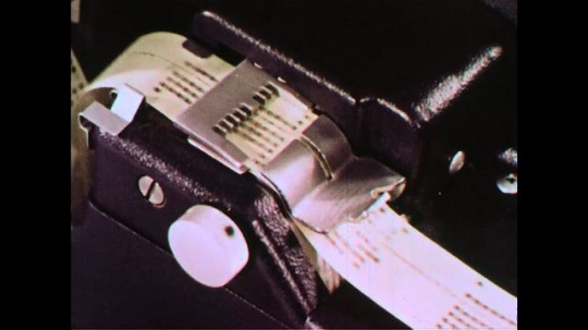 UNITED STATES 1960s: Holes being punched into a paper by a typewriter ...