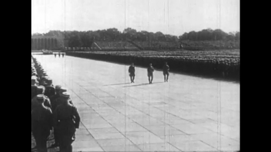 UNITED STATES 1950s: Soldiers watch and hold swastika flags as Adolf ...