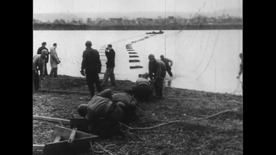 UNITED STATES 1950s: Troops construct bridge across river / Officer ...