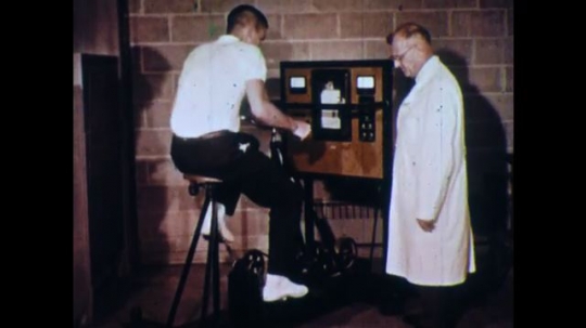 UNITED STATES 1960s: Man watches boy peddle stationary bike / Men ...