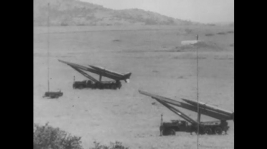 EUROPE, 1950s: Rockets being launched from guns on ground. Men in armed ...