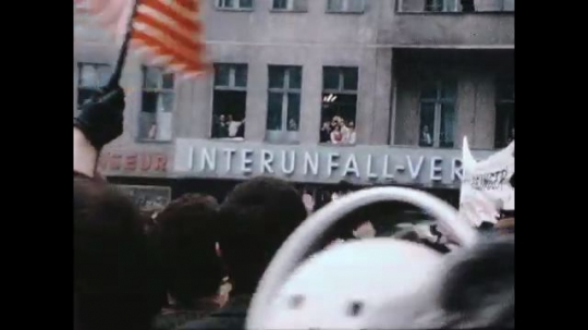UNITED STATES 1960s: View from inside crowd, hand waving flag / Tilt ...