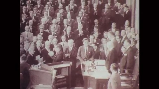 1960s: Crowd claps as John F. Kennedy takes podium. Crowd sits down ...