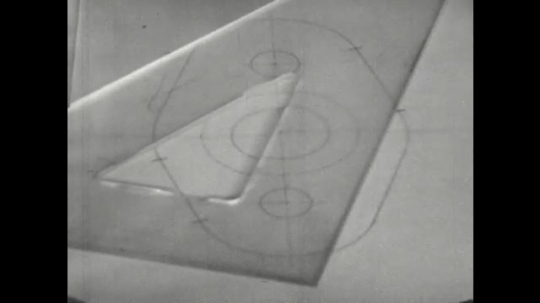 UNITED STATES: 1960s: hand moves plastic triangle over drawing. Fingers ...