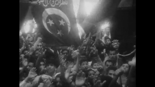 1960s: Crowd cheering. Man yelling in crowd. View of desert, fade out ...