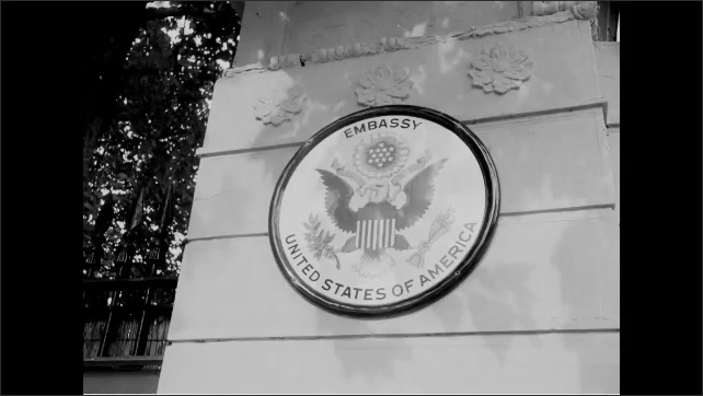 1950s: Low angle shots of Soviet statue. Motorcade driving. Sign on ...