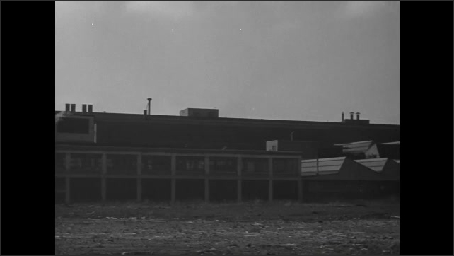 1940s: :Large factory building exterior with vapor billowing from small ...
