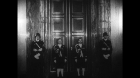 Europe 1940s: men guard door of building. Quotation from Hitler about ...