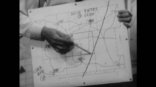 United States: 1950s: Man points at map of radiation dose rates ...