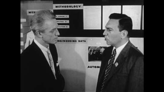 UNITED STATES: 1950s: two men talk by medical poster presentation at ...