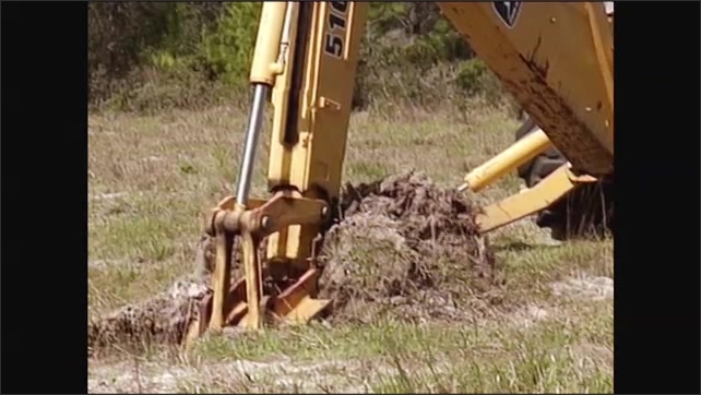2000s: Hands holding levers. Excavator bucket digging in soil ...