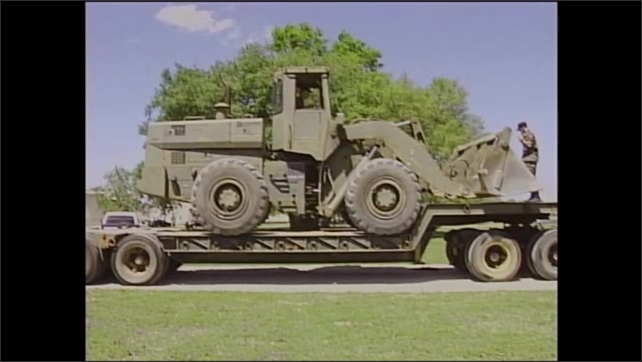 2000s: Soldier skillfully maneuvers vehicle onto trailer, while a man ...