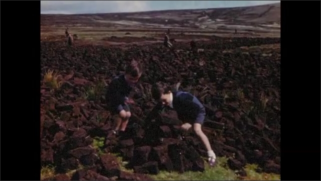 1950s: Boys stack clay bricks into small cairns in field. – Archival ...