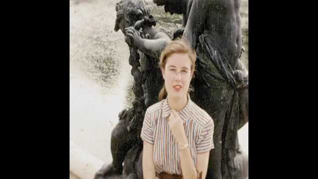 1950s: Young woman poses by grand statue in French fountain, poses by ...