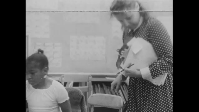 1970s: Female teacher circulates with students and teaches class ...
