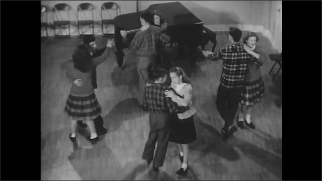 1950s: Young man and woman stand together. Couples bow to each other ...