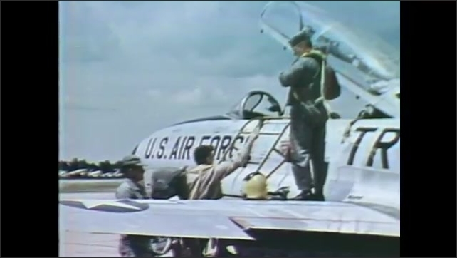1960s: Air Force pilots put on gear and climb into cockpit of fighter ...