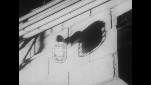 1950s: UNITED STATES: operator controls reactor pile. Man monitors ...