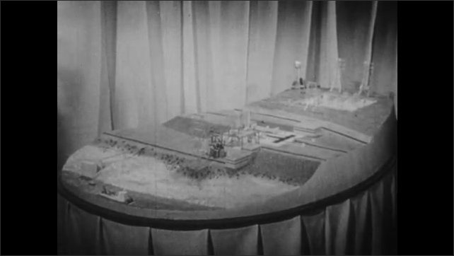 1950s: UNITED STATES: Man holds metal next to gage. Model of nuclear ...