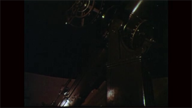 1950s: Observatory doors open, exposing telescope. Man looks through ...