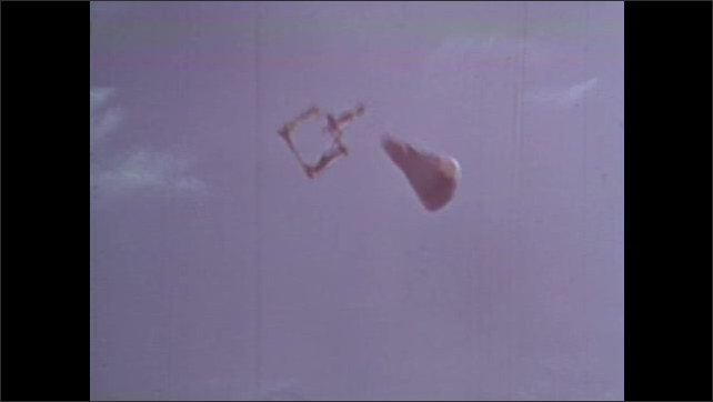 1960s: Airplane in the air. Test space capsule is pushed out the back ...