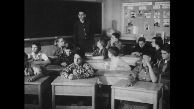1950s: Students sit in classroom. Children raise hands and speak. Boy ...