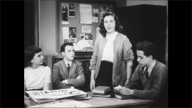 1940s: Classroom. Students stand and speak. Young woman shows posters ...