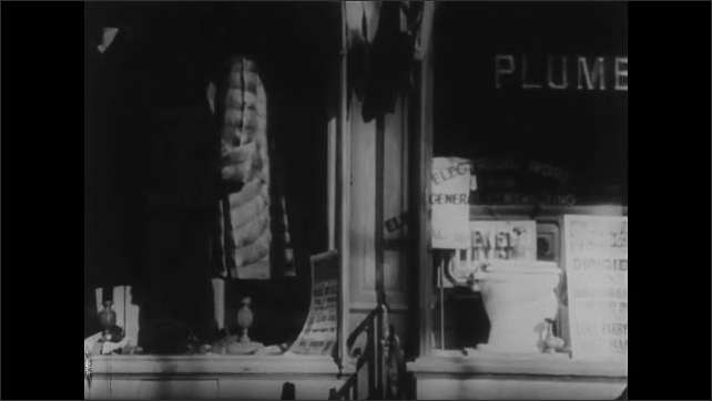 1930s: View of store window, awning lowering. View of storefront. Close ...