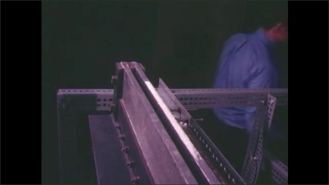 1960s: White boiler plate situated in metal casing. Man is pouring ...