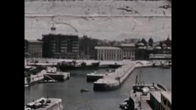 1950s: City. Ships in harbor. Bridge over canal. – Archival Footage