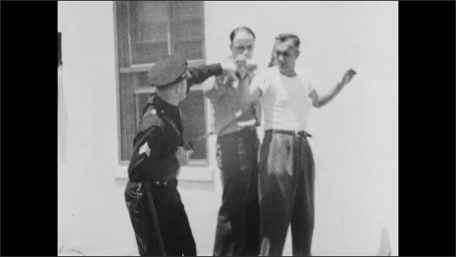 1940s: police officer patting down two men with hands against wall ...