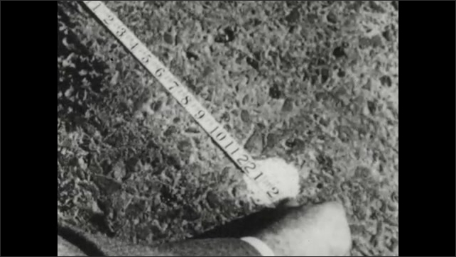1950s: Men use tape measure to find distance between marks on road ...
