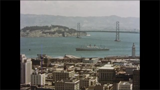1950s: UNITED STATES: man looks through window. View across city ...
