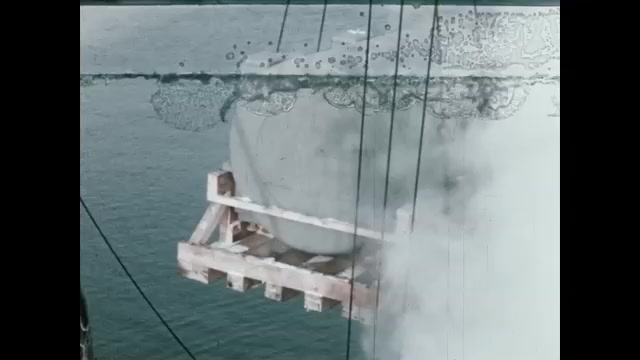 1950s: Crane lifting tank. Close up of man. Cranes lowering bags of ...