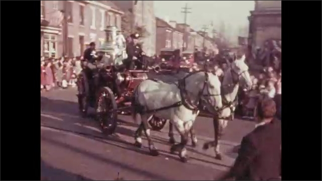1920s: Parade route turns corner, horse drawn fire engine, fireman ...