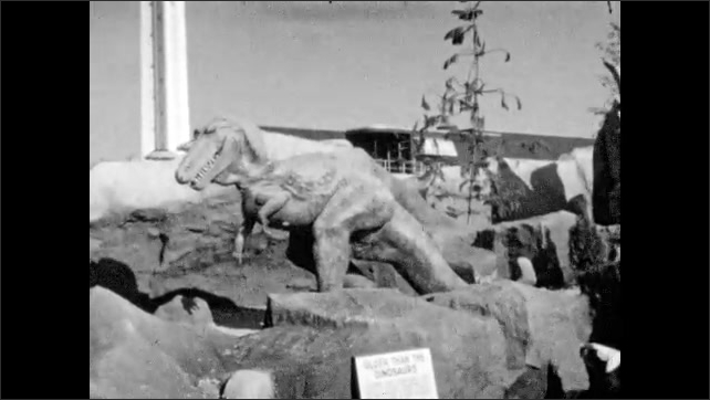1930s: Crowds walk past attraction buildings at World’s Fair. Large ...