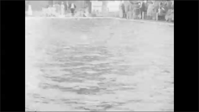 1920s: Woman in bathing suit and swim cap dives off a diving board into ...