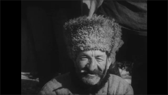 1940s: CAUCASUS, EUROPE: men in hats look at camera. Men sit around and ...