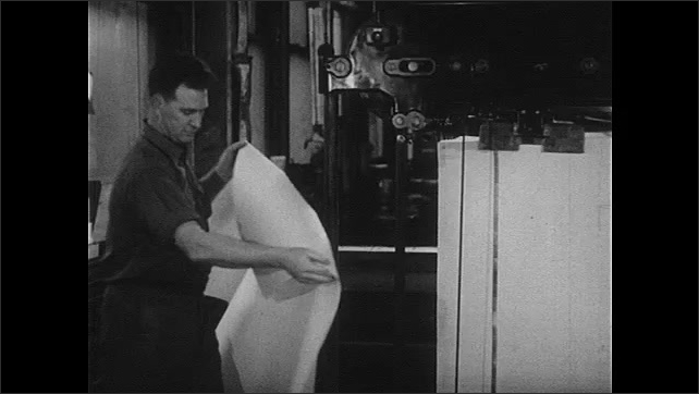1940s: Printing press. Man removes map and lays on table. Men study map ...