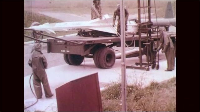 1950s: Army official stands at sign. Men work around weapons – Archival ...