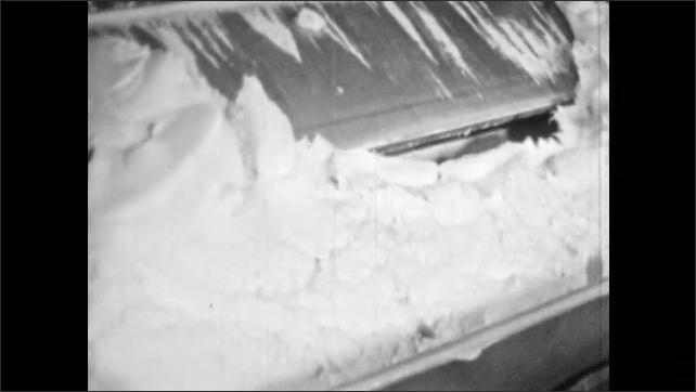 1960s: Butter slides down industrial chute from churn. Man removes ...