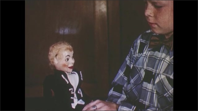 1950s: Doll appears on school desk, boy looks surprised. Puppet and boy ...