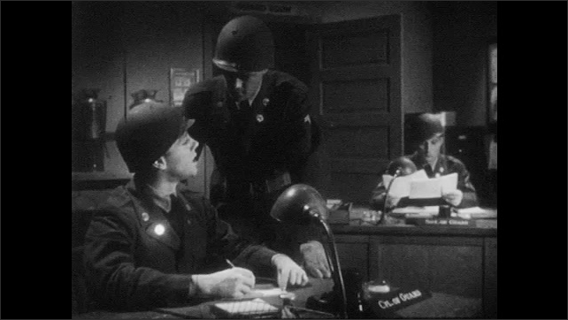 1950s: UNITED STATES: guard stands by box. Guards work in office. Men ...