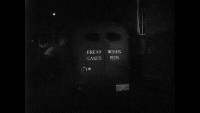1950s: UNITED STATES: men load bakery van. Guard calls main gate ...